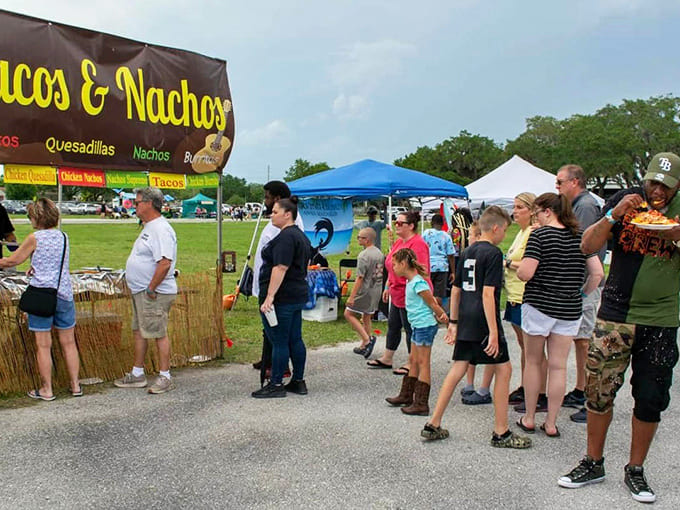 Taco stands line the festival path where families stroll between colorful vendor booths promising Mexican-inspired deliciousness at every turn.