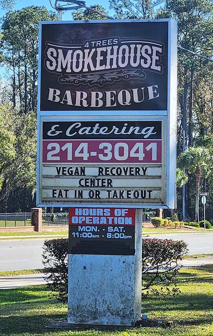 The sign says it all: smokehouse perfection awaits behind these doors, along with sides worth writing home about.