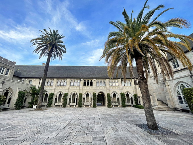 Palm trees stand sentinel in the peaceful courtyard, nature's columns complementing the man-made arches in this tranquil stone oasis.