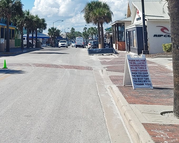 Palm trees stand sentinel along Flagler Avenue, guiding visitors toward the Atlantic's embrace at the street's end.