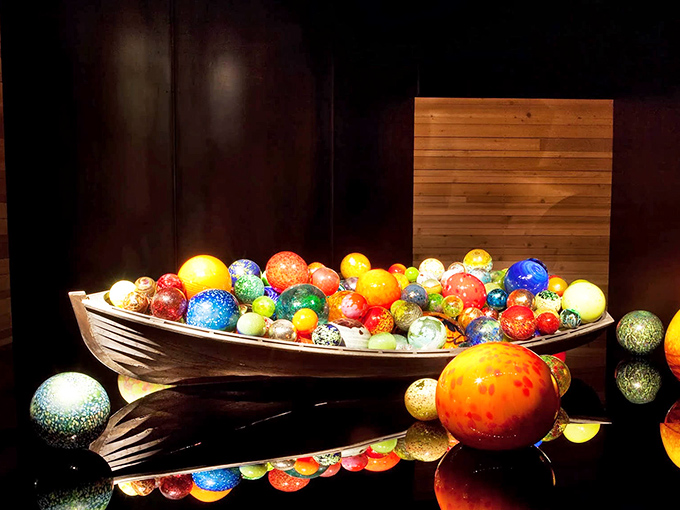 The Float Boat installation features colorful glass orbs nestled in wooden vessels, like precious jewels harvested from some magical sea.