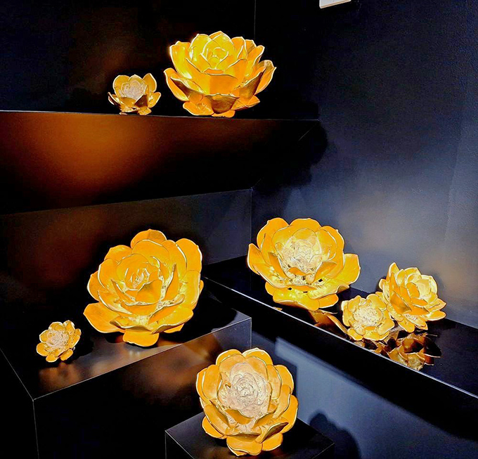Golden glass flowers bloom eternally under perfect lighting, capturing sunshine even on cloudy days &ndash; nature reimagined through an artist's fiery craft.