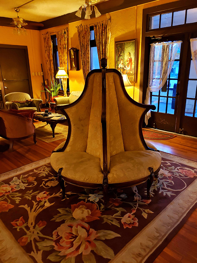 That conversation chair isn't just a Victorian curiosity&mdash;it's practically designed for chatting with someone from the other side. The warm glow can't quite dispel the room's mysteries.