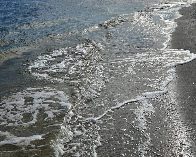 The gentle kiss where Gulf meets shore &ndash; each wave erases footprints, reminding visitors that nature always has the final word.