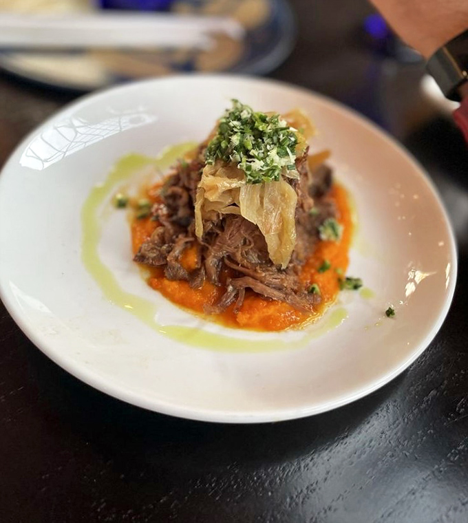This slow-braised beef practically melts on your fork, served atop a vibrant orange purée that adds a surprising pop of flavor.