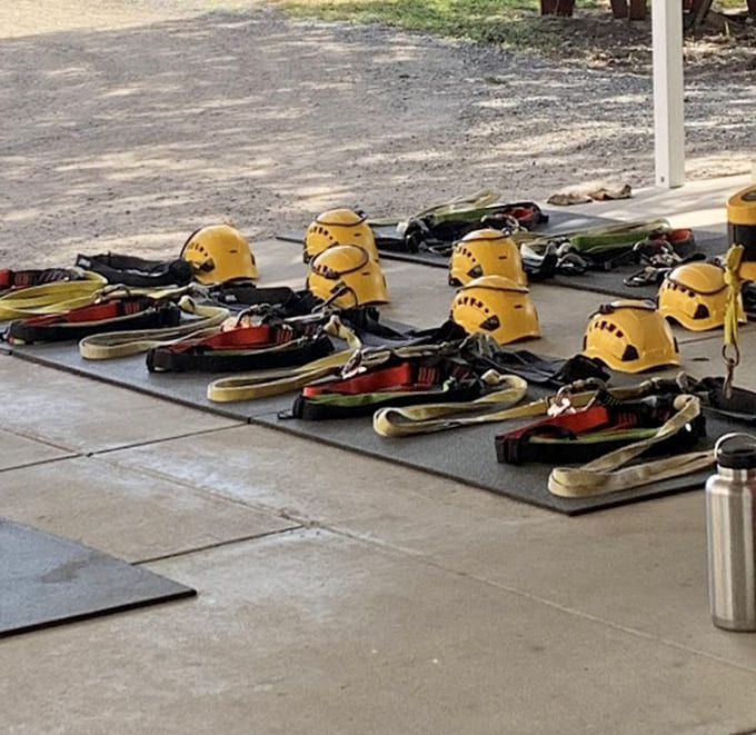 Rows of yellow helmets waiting like eager students, ready to protect heads while hearts race across the canyon zip lines ahead.