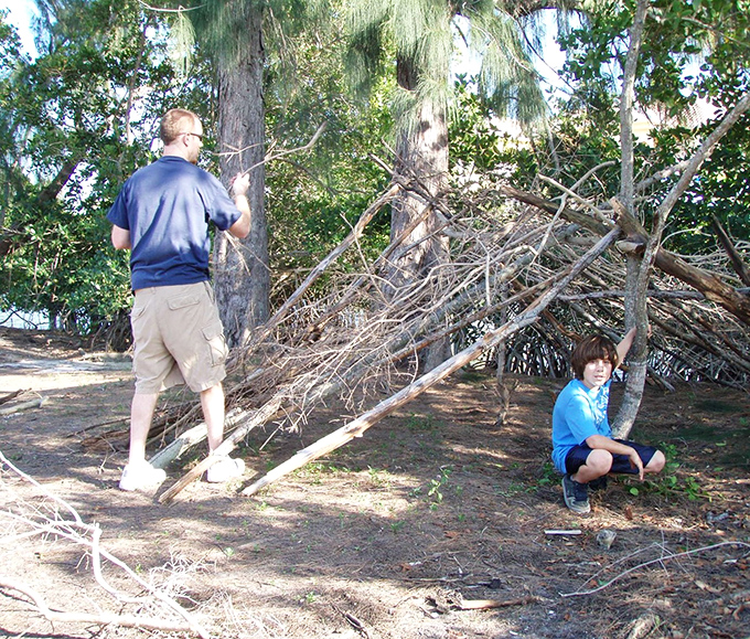 Adventure begins with exploration! Visitors discover the joy of building natural shelters from fallen branches on Samsons Island's shores.