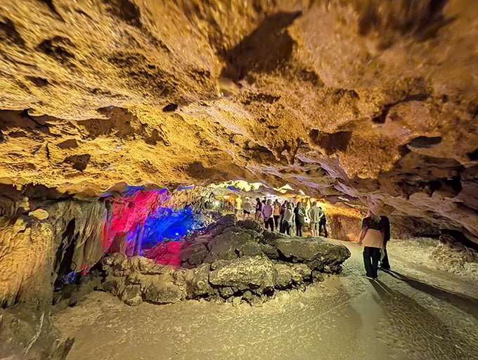 Visitors marvel at nature's handiwork, bathed in the otherworldly glow of carefully placed lights highlighting millennia of creation.