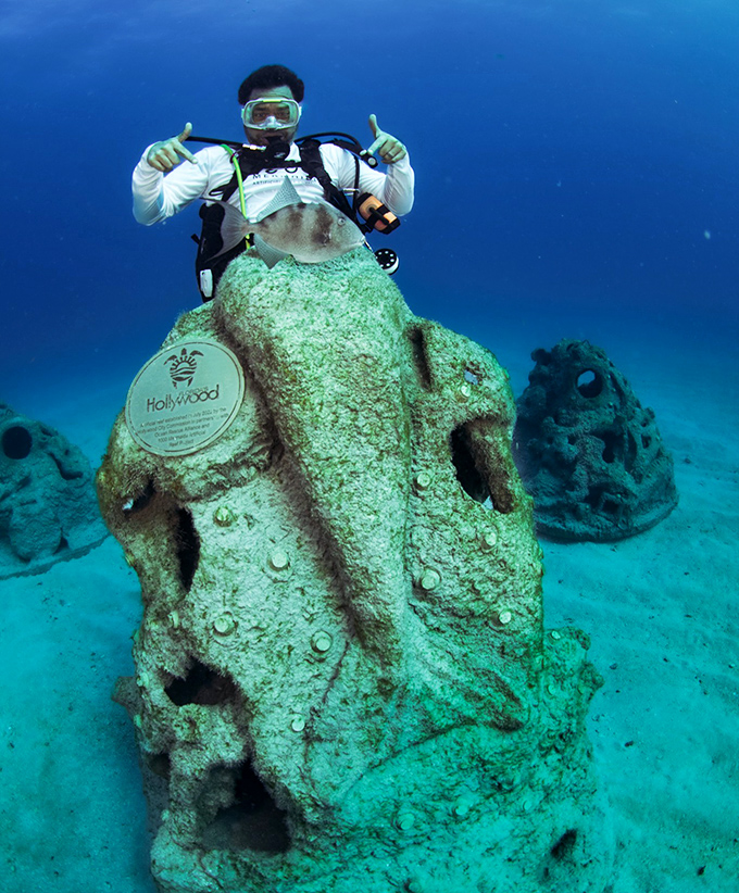 "Just hanging out with my underwater friends!" This diver gives a thumbs-up beside a sculpture becoming its own ecosystem.
