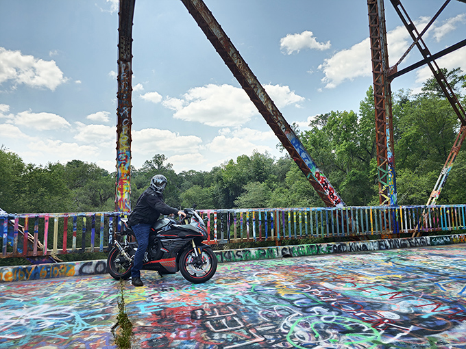 Adventure seekers find their own path across this colorful monument, where even motorcyclists pause to appreciate the unexpected roadside gallery.