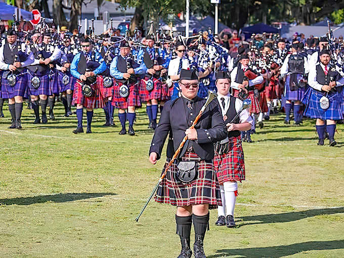 Bagpipers in traditional Scottish attire march in formation at the Dunedin Highland Games, bringing Scotland's heritage to Florida's Gulf Coast.