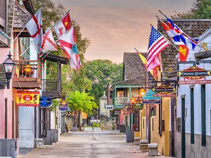 Colorful flags flutter above St. Augustine's historic district, where centuries-old buildings line cobblestone streets.