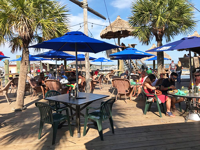 Sunshine, swaying palms, and a bustling outdoor crowd – The Conch House's deck offers front-row seats to Salt Run's peaceful beauty.