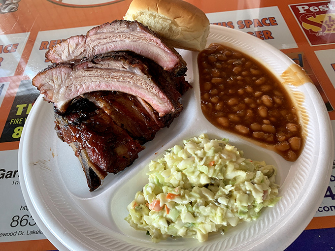 A perfect barbecue trinity: tender baby backs, creamy coleslaw, and baked beans that have clearly been simmering in flavor heaven.