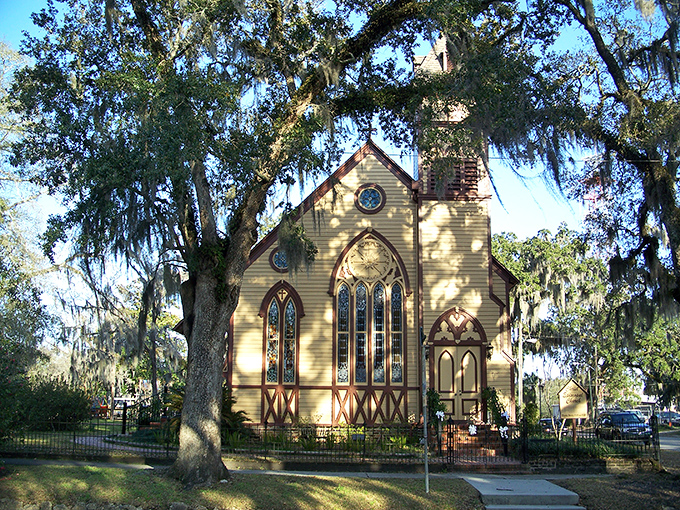 Christ Episcopal Church's Gothic Revival style stands as a yellow beacon of faith, its pointed arches reaching skyward like prayers.