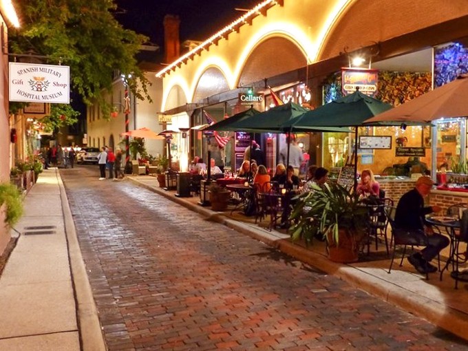 Evening lights transform the street into pure romance, with restaurants spilling onto cobblestones and that golden glow making everything look like a travel poster come to life.