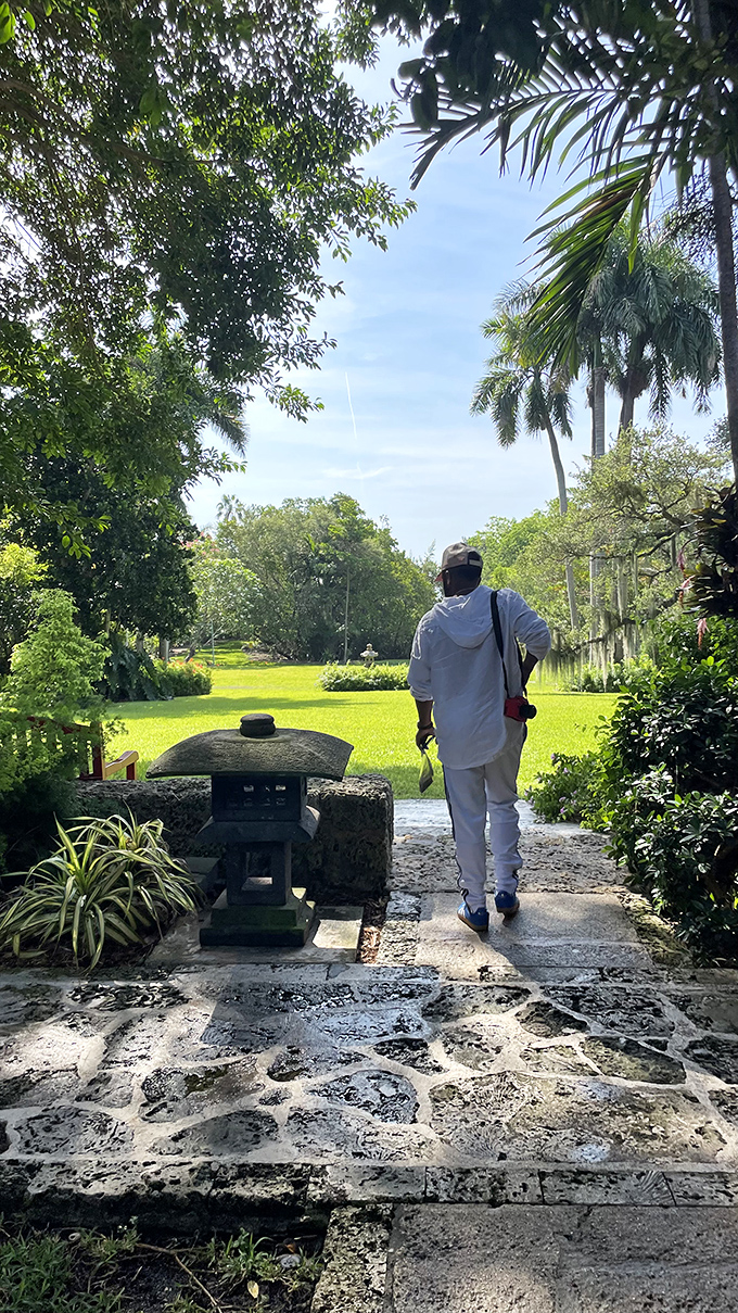 A peaceful wanderer explores The Kampong's grounds, where stone pathways lead through gardens that feel worlds away from city life.