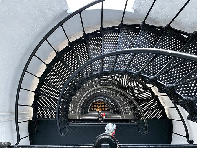 Inside the Lighthouse: The spiral staircase curves hypnotically downward, a dizzying metal corkscrew that's either architectural brilliance or a clever torture device for visitors.