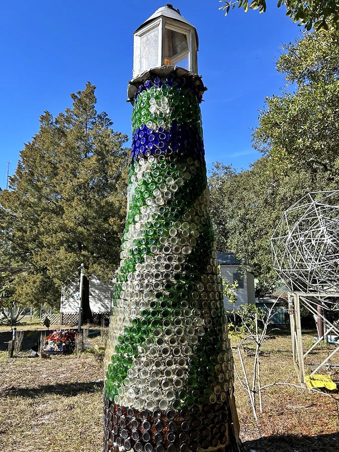 The lighthouse structure reaches skyward, its colorful glass pattern resembling an abstract painting when viewed up close against the clear blue Florida sky.