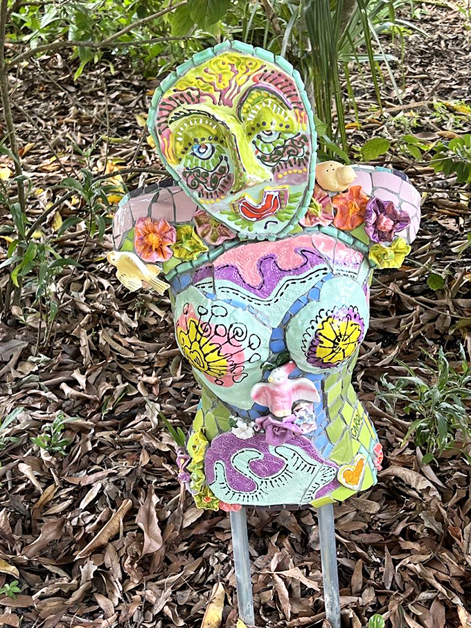 This mosaic mannequin stands guard in the garden like a colorful sentinel, probably judging your plain, untiled clothing choices.