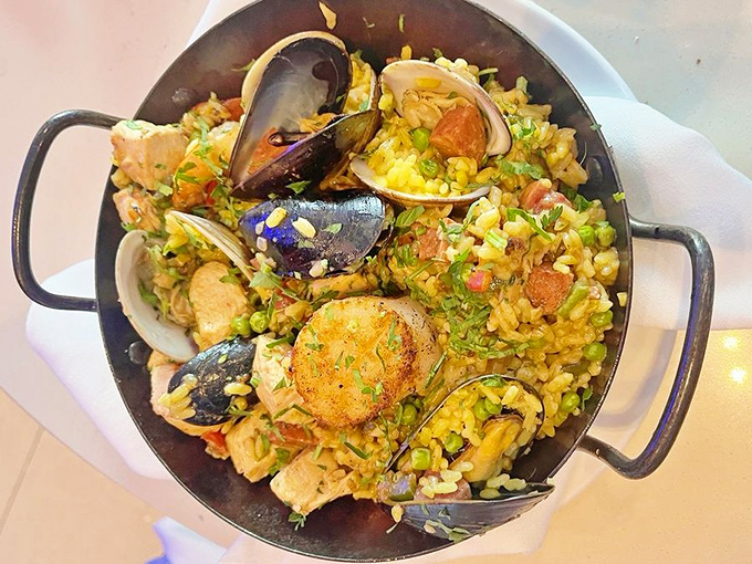The seafood paella arrives like a colorful celebration in a pan &ndash; mussels, clams and tender chunks of fish nestled among saffron-kissed rice.