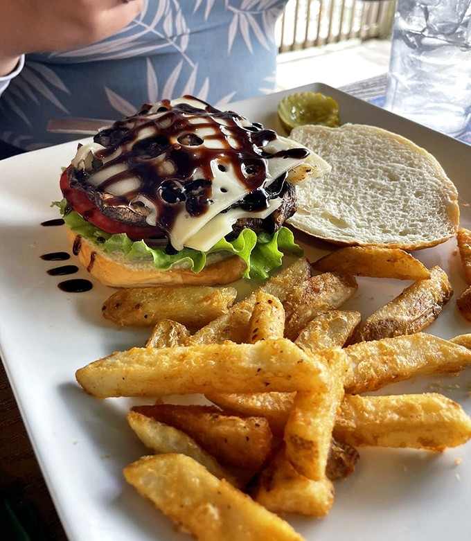 The Portobello burger arrives drizzled with balsamic glaze, proving vegetarians needn't feel left out at this seafood-centric paradise.