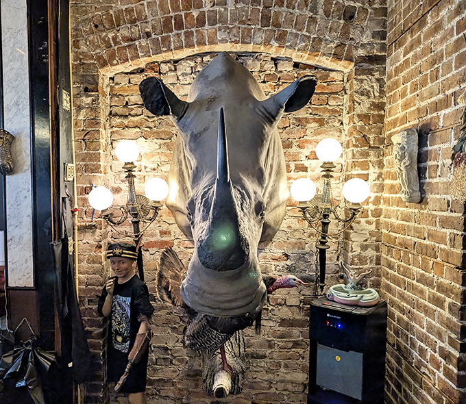 This imposing rhinoceros head mount dominates the brick wall, creating a striking contrast between industrial backdrop and natural wonder.