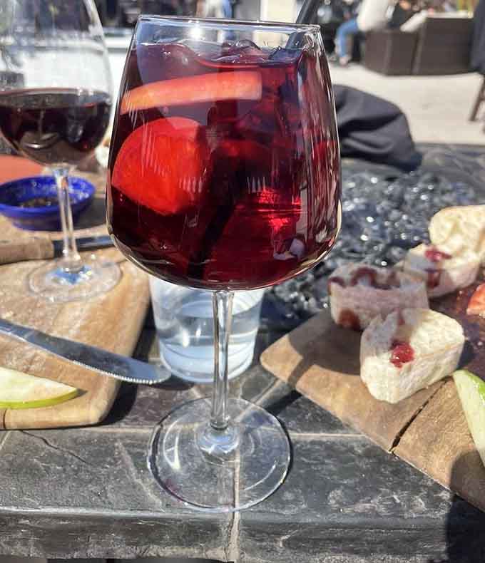 Red sangria loaded with fruit looks like summer decided to jump into a glass and make itself comfortable for the afternoon.