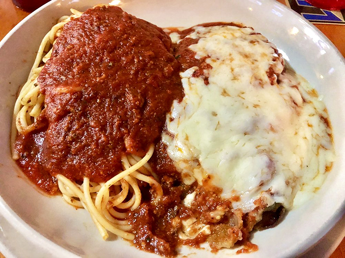Spaghetti and eggplant parmesan share a plate in perfect harmony, proving that sometimes the best relationships have a little sauce to spice things up.