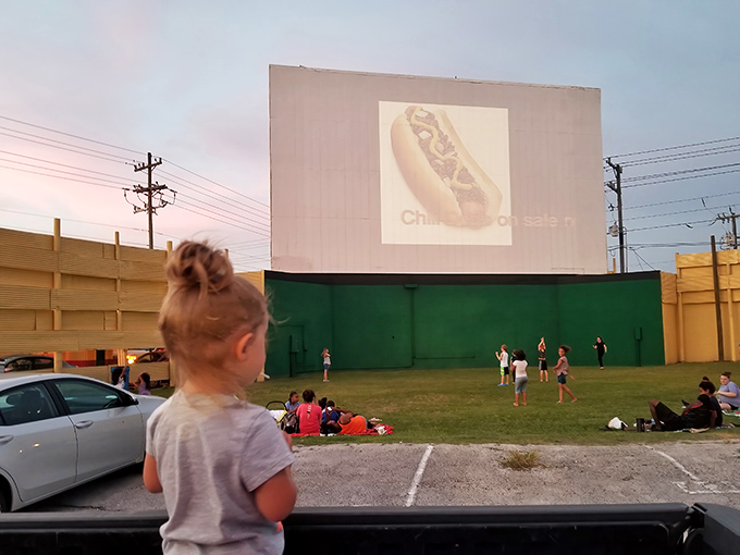 Young moviegoers experience the freedom of outdoor cinema, where running around before showtime is part of the tradition.