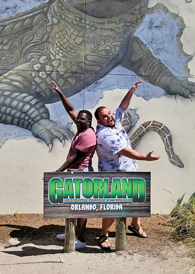 Striking a pose at the Gatorland sign, these visitors celebrate conquering their reptile fears with triumphant arms raised high.
