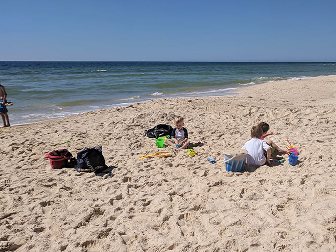 Children playing: Childhood as it should be – unplugged, sandy, and completely absorbed in the timeless joy of beach engineering.