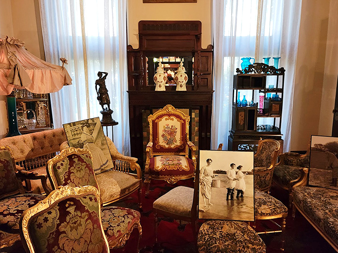 Victorian excess comes alive in this sitting room, where plush furniture, ornate fireplace, and carefully arranged photographs transport visitors to another era.
