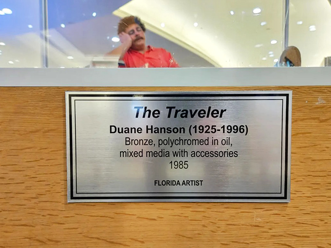 Artist Duane Hanson's plaque reveals the genius behind "The Traveler" &ndash; a Florida artist who specialized in startlingly lifelike human figures.