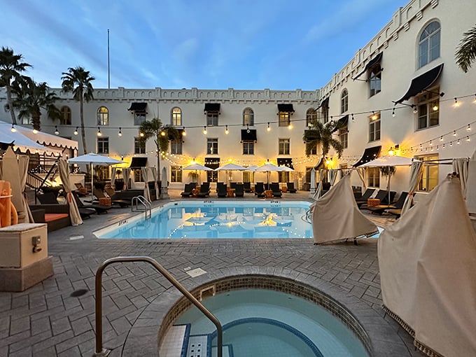 As twilight descends, the pool area transforms into a magical oasis where string lights reflect in azure waters and conversations flow as freely as cocktails.