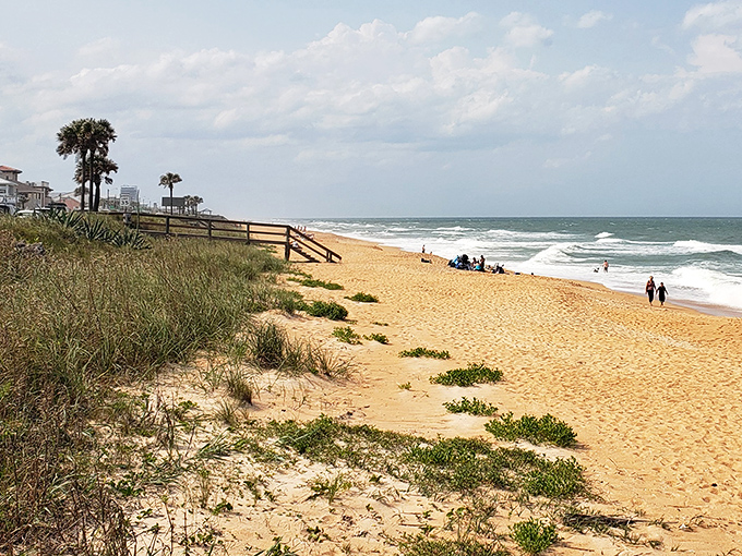 The distinctive cinnamon-hued sand meets gentle waves, creating a shoreline that's as unique as the town itself.