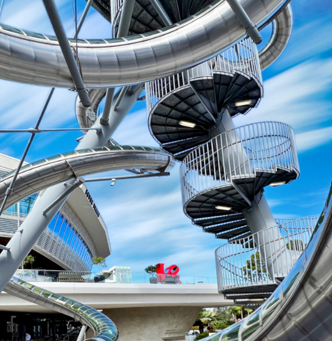 Spiral staircases wind upward like metallic DNA strands, each step bringing you closer to that moment of exhilarating free-fall.