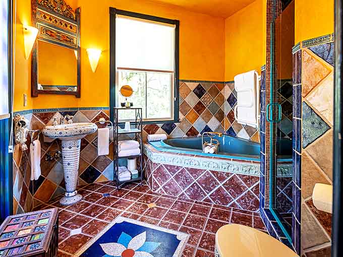 This vibrant bathroom is a jewel box of color with hand-painted tiles and a deep soaking tub perfect for relaxing after a day of ghost hunting.