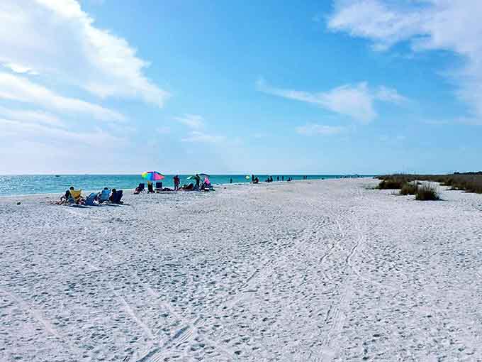Beach enthusiasts stake their claim with colorful umbrellas, tiny outposts of joy on this vast sandy canvas.
