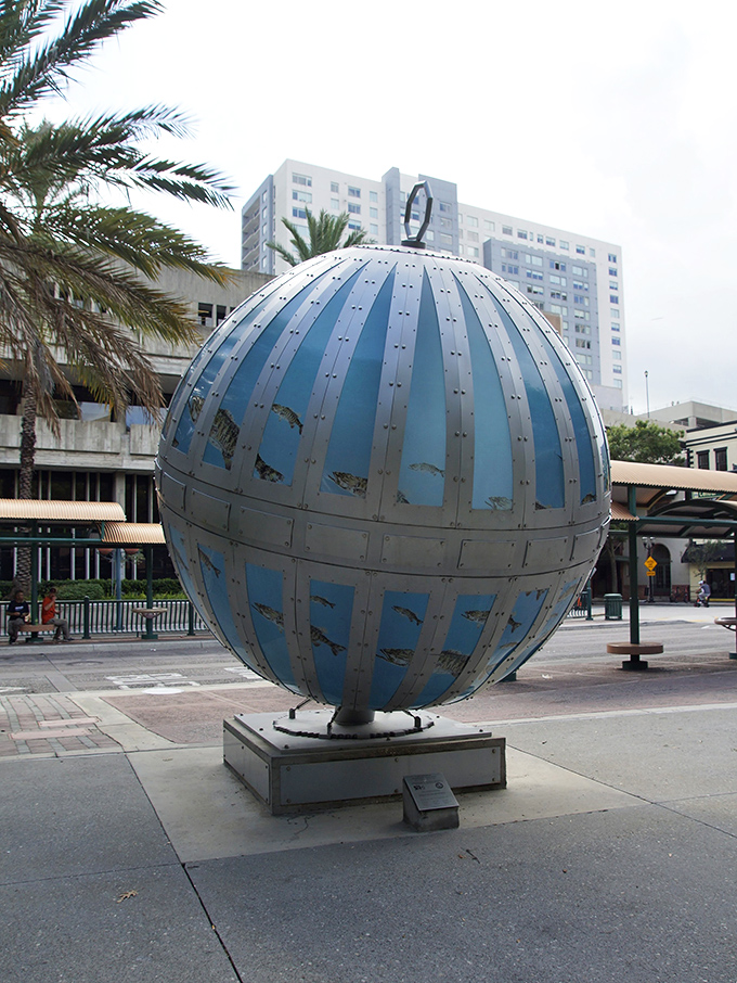 Even under cloudy skies, the metallic stripes and azure panels maintain their visual impact, proving great art shines regardless of weather conditions.