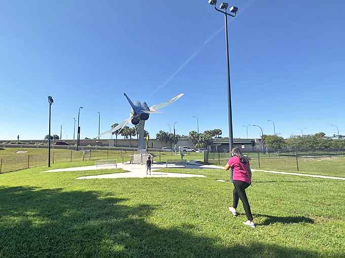 Visitors stroll beneath 30,000 pounds of suspended aviation history, probably contemplating their suddenly less impressive weekend plans.