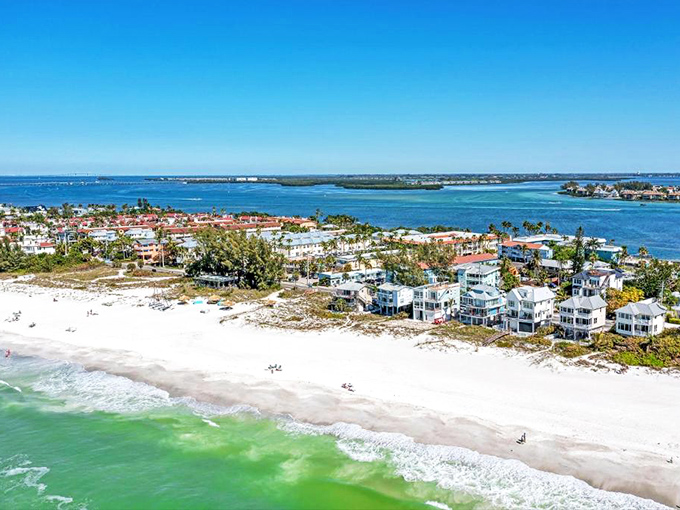 Anna Maria Island's pristine coastline stretches like nature's perfect smile, with sugar-white beaches meeting emerald waters while charming beach homes stand as lucky spectators.