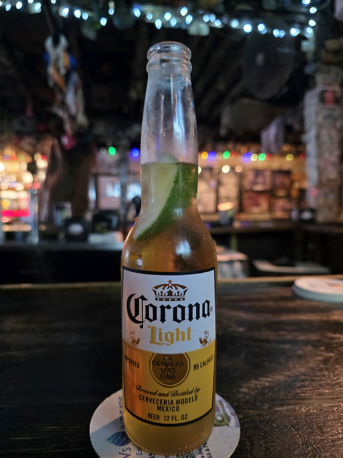 A Corona with lime awaits its drinker, condensation beading on the bottle like morning dew on a Key West palm leaf.