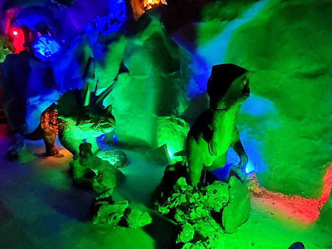 Prehistoric predators lurk in the neon-lit Dinosaur Cave, where this velociraptor's glowing green presence makes even adults think twice before proceeding.