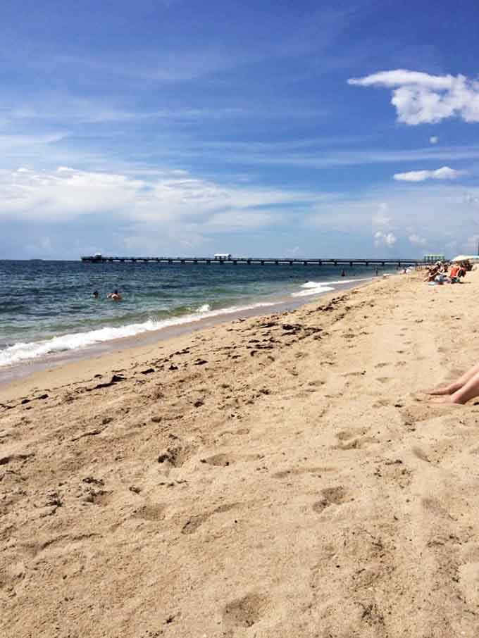 Pristine sand stretches toward that iconic pier, looking so perfect you almost feel guilty about walking on it, but only almost.