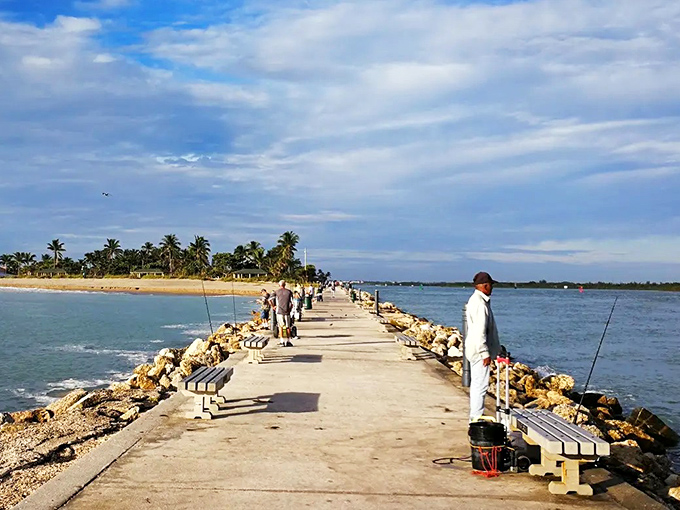 Local anglers line the jetty at dawn, their silhouettes creating a timeless tableau against the backdrop of Florida's awakening waters.