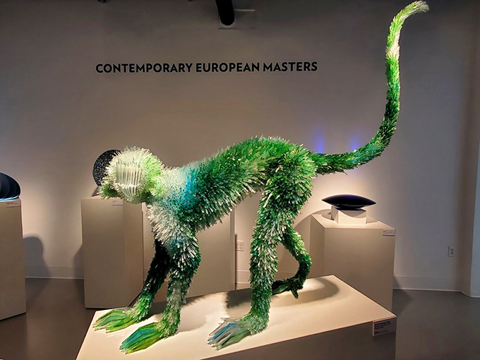 This cheeky green glass monkey looks ready to leap from its pedestal &ndash; proof that glass artists have both technical skill and playful imagination.