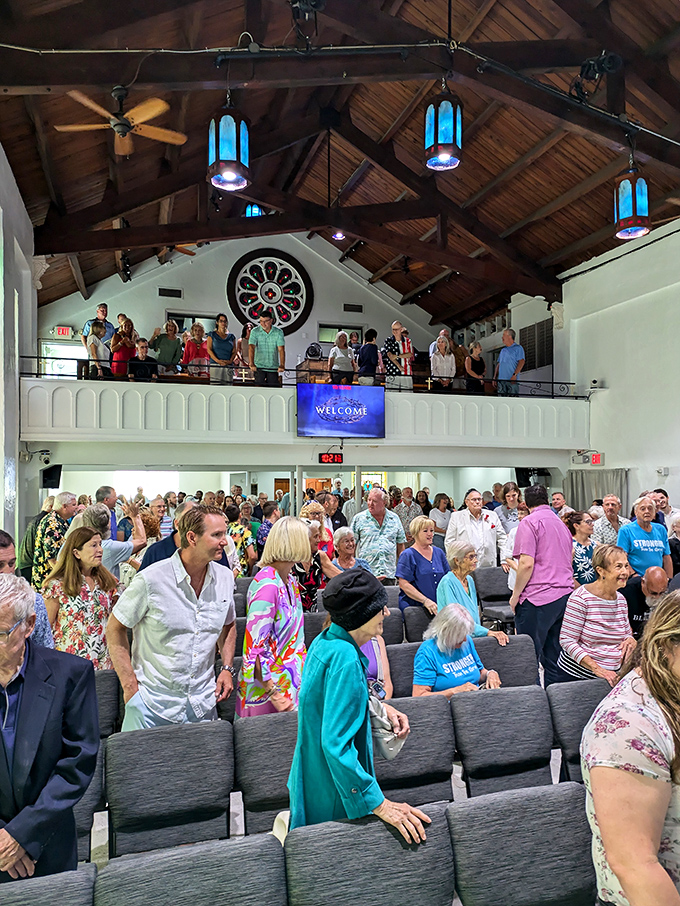 Sunlight dances through stained glass windows, casting colorful patterns across wooden pews in this peaceful sanctuary.