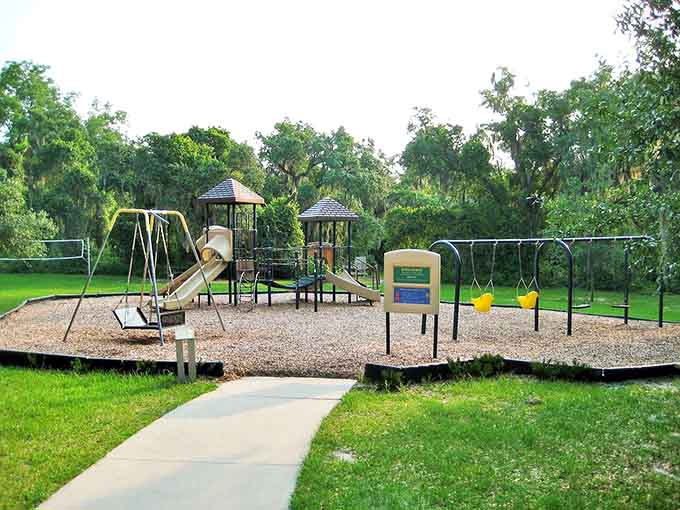 The playground sits ready for action under those protective oaks, because even kids' fun time is better with a side of natural shade and Spanish moss ambiance.