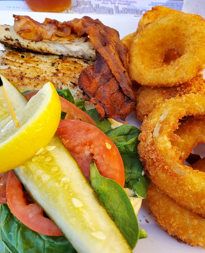 Crispy onion rings and perfectly cooked fish create a plate that's both comfort food and coastal luxury in one delicious package.